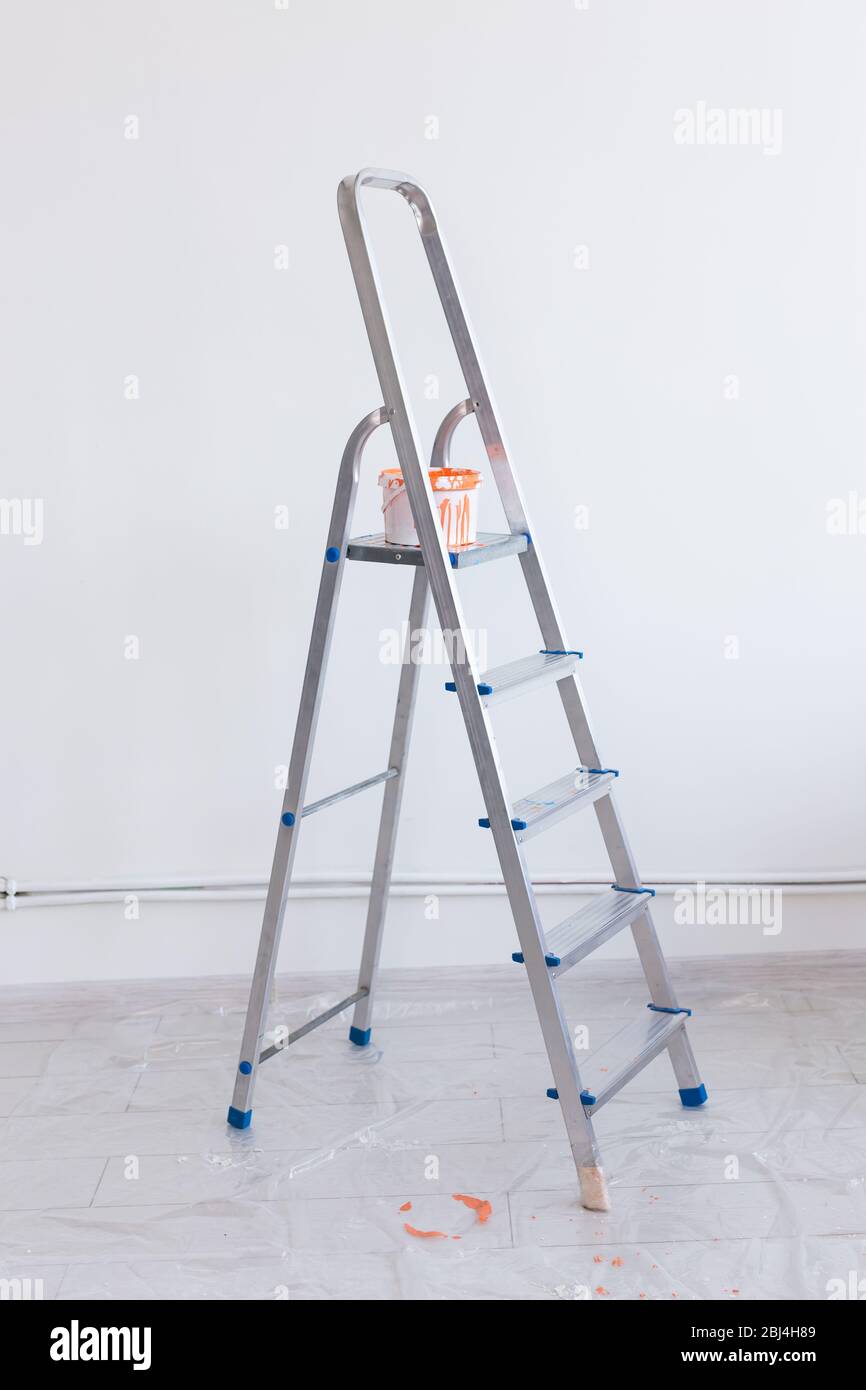 Ladder with paint in bucket near color wall indoors. Renovation and ...