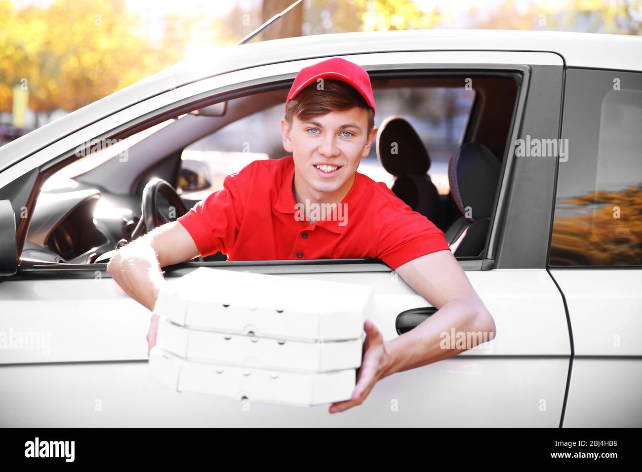 Pizza delivery boy in car, close-up Stock Photo - Alamy