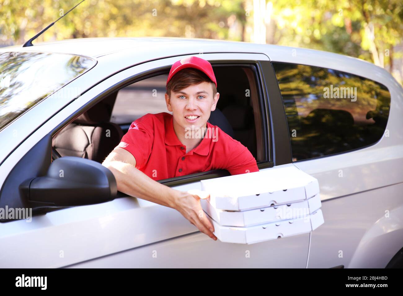 Pizza delivery boy in car, close-up Stock Photo - Alamy