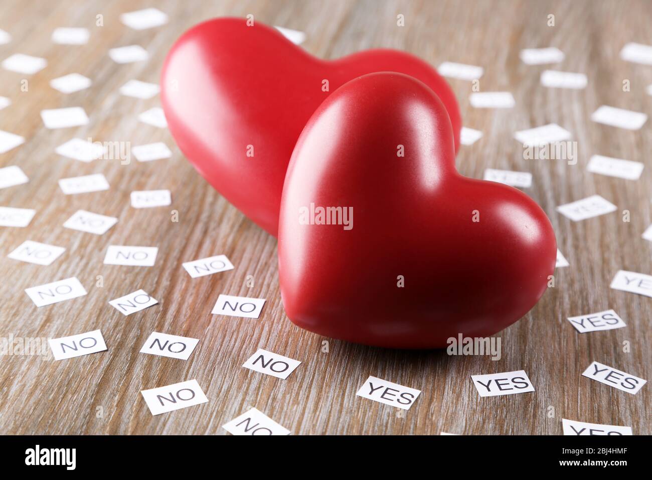 Two red hearts with yes and no on wooden background Stock Photo - Alamy