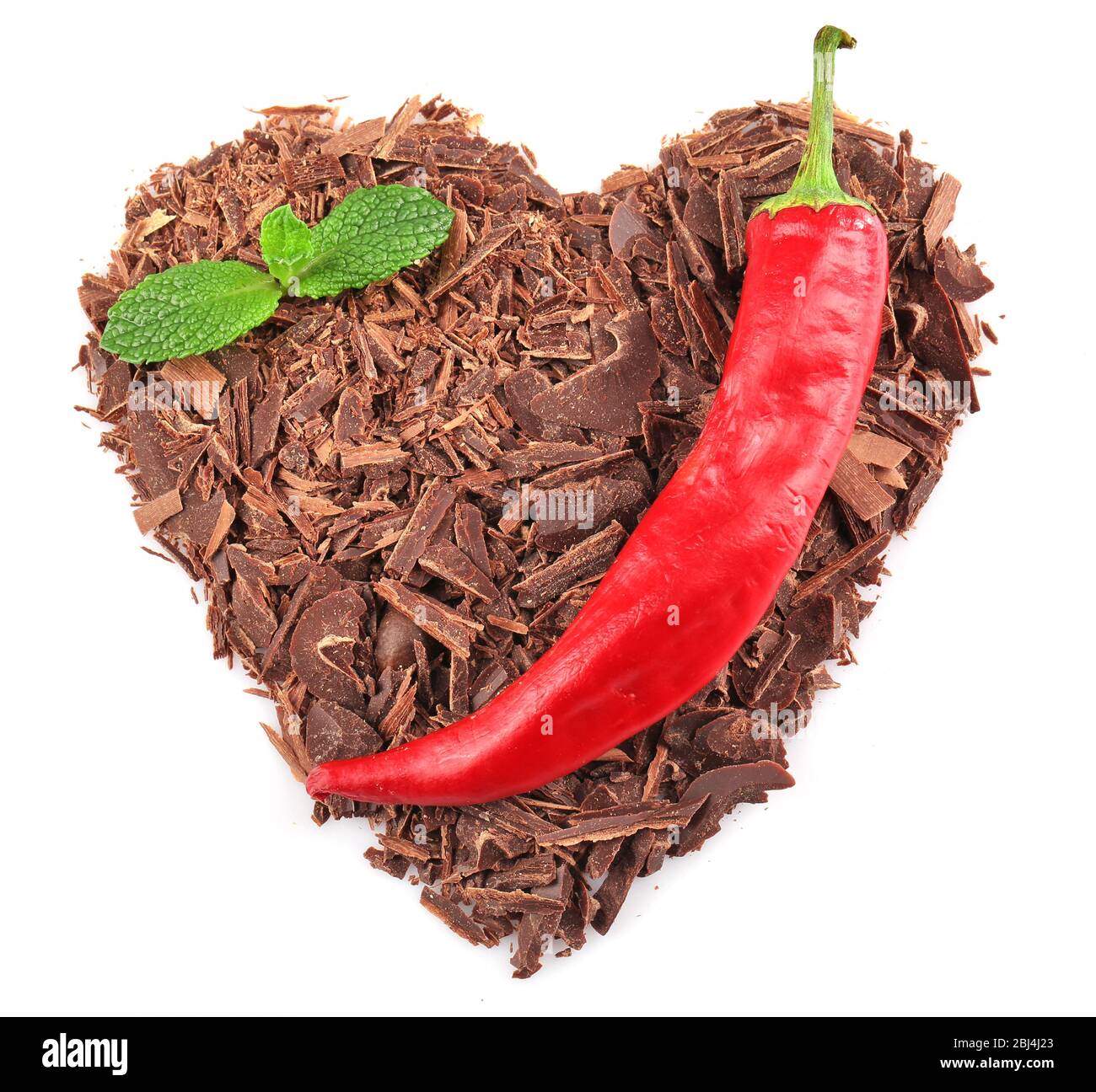 Dark chocolate shavings in shape of heart with chili pepper isolated on ...