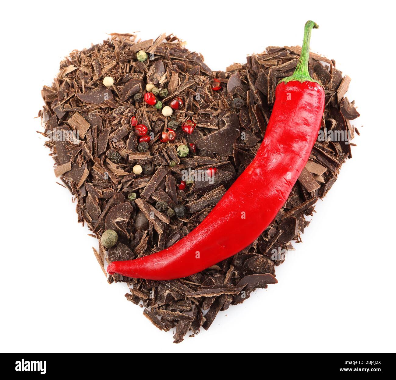 Dark chocolate shavings in shape of heart with chili pepper isolated on ...