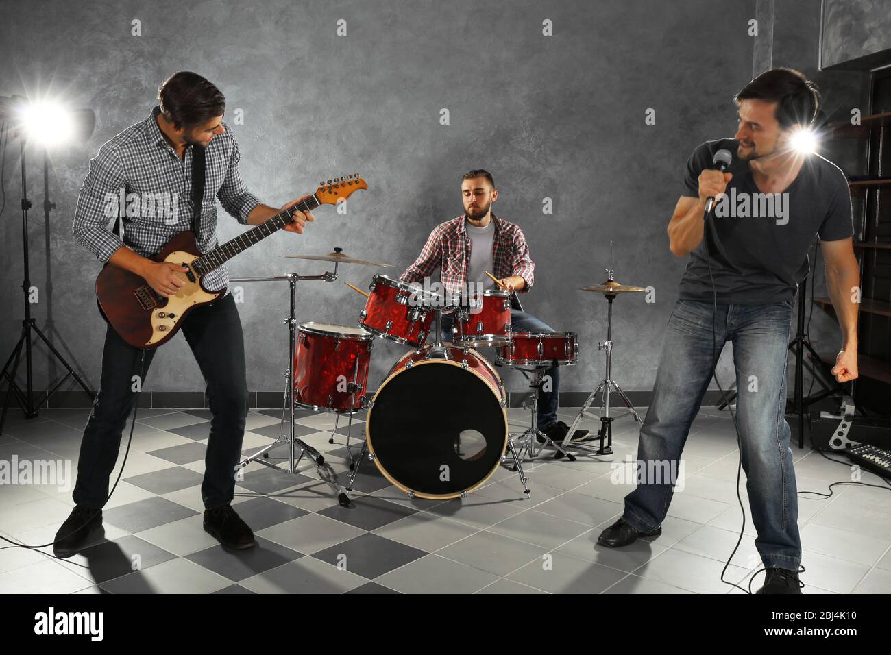Musicians playing musical instruments and singing songs in a studio ...