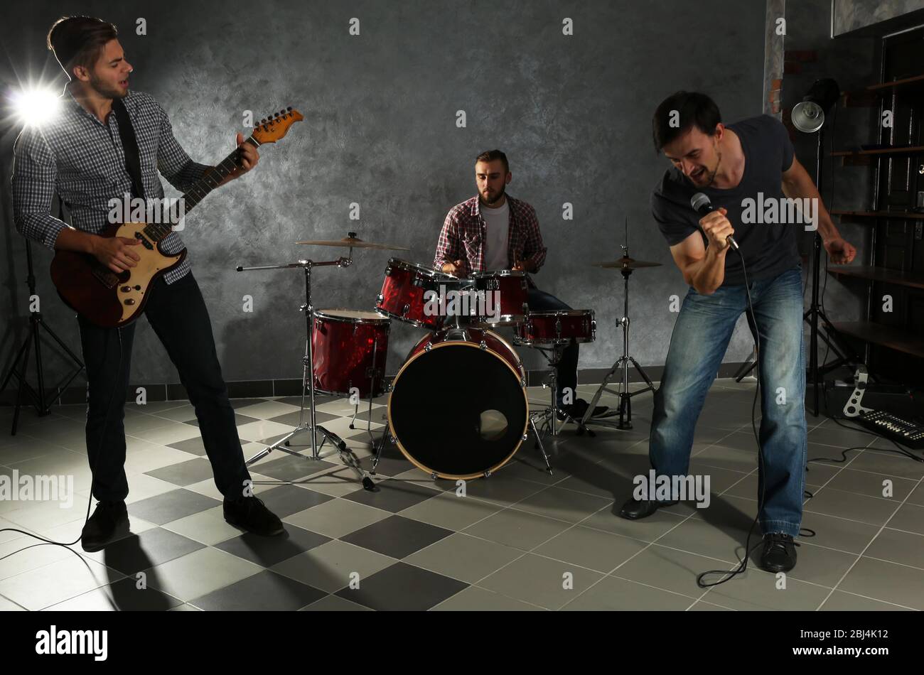 Musicians playing musical instruments and singing songs in a studio ...