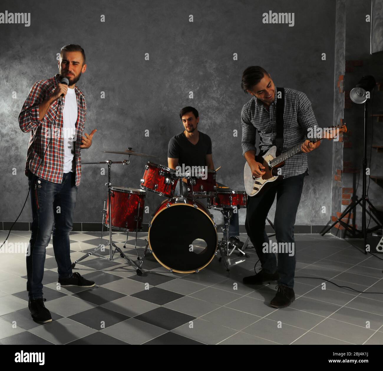 Musicians playing musical instruments and singing songs in a studio ...