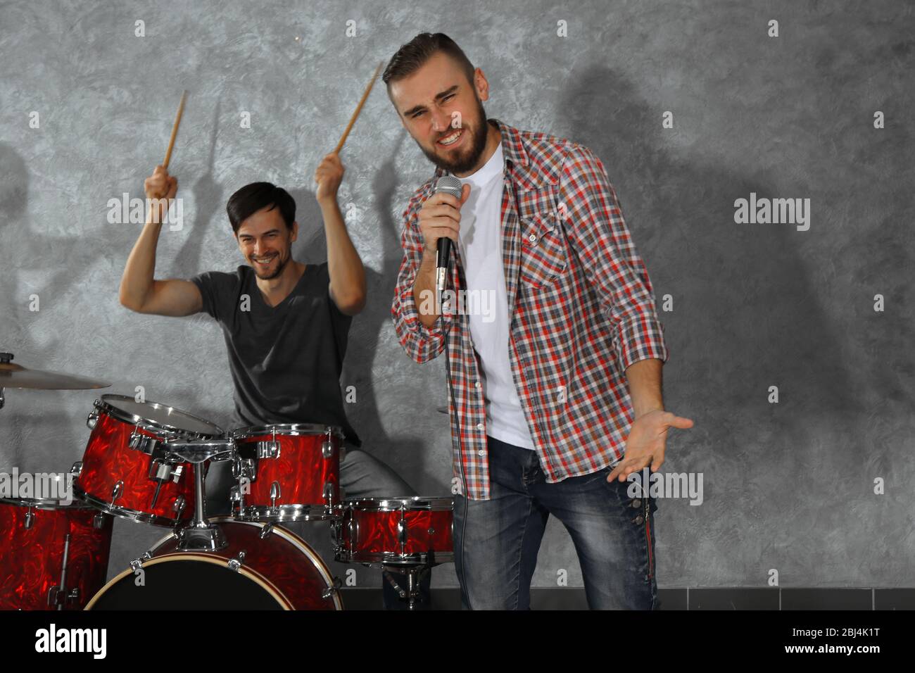 Musicians playing musical instruments and singing songs in a studio ...