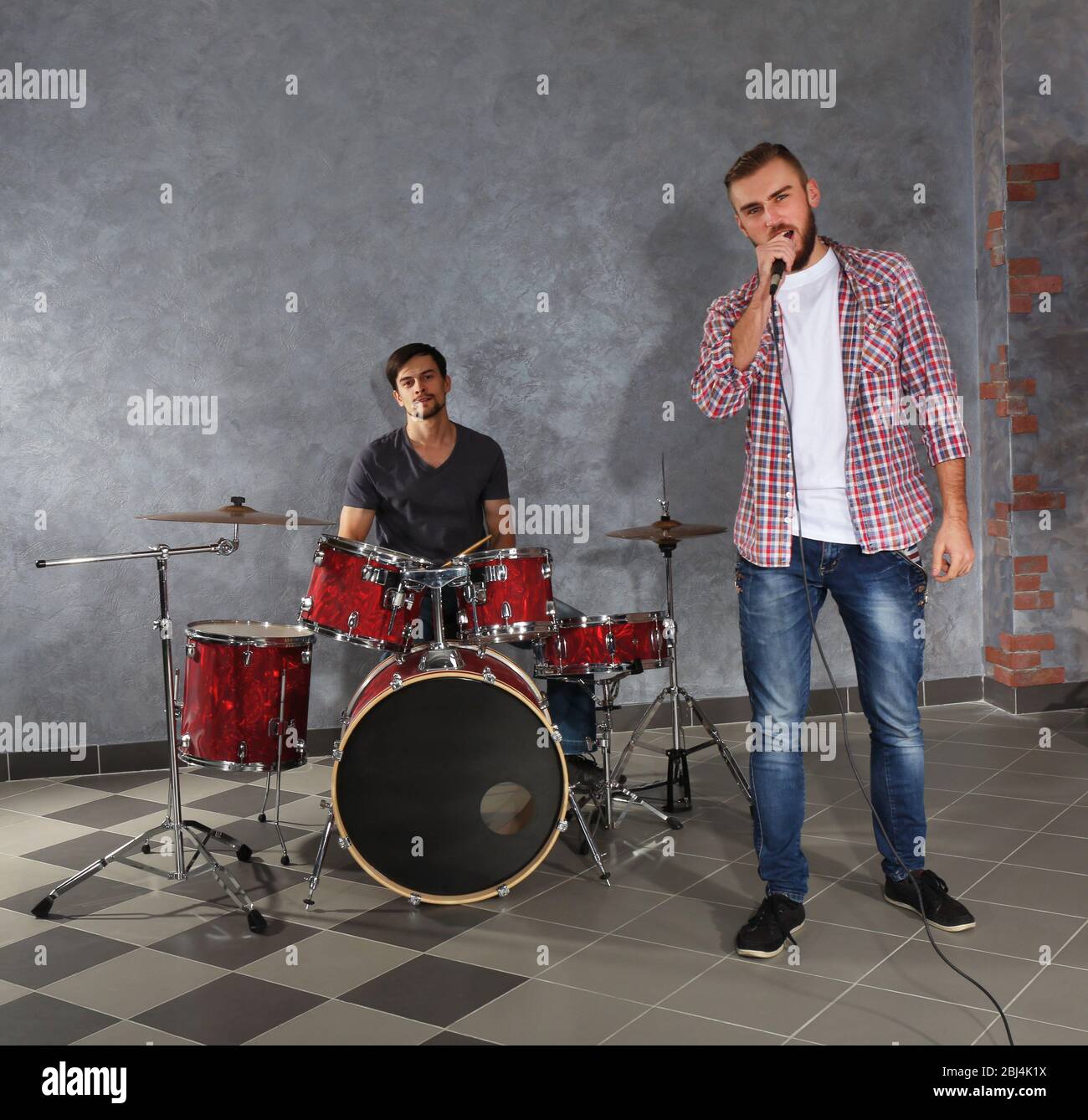 Musicians playing musical instruments and singing songs in a studio ...