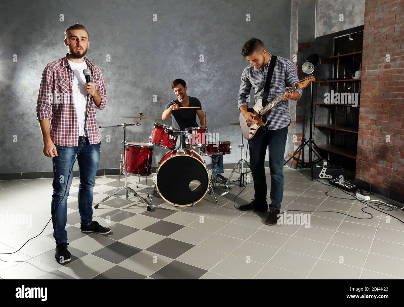 Musicians playing musical instruments and singing songs in a studio ...