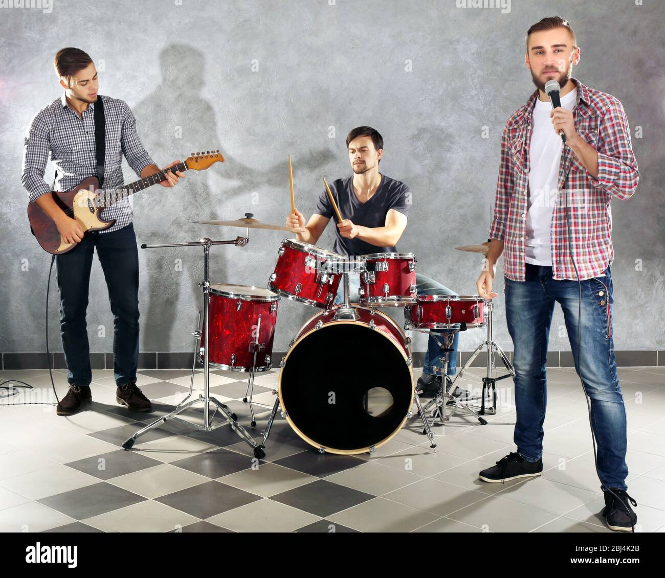 Musicians playing musical instruments and singing songs in a studio ...