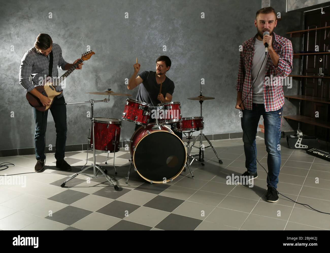Musicians playing musical instruments and singing songs in a studio ...
