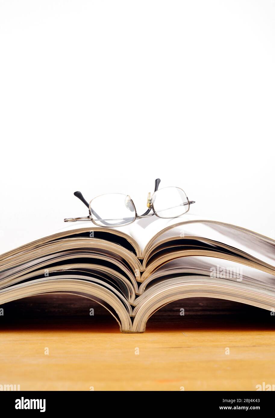 glasses on a pile of journals Stock Photo - Alamy