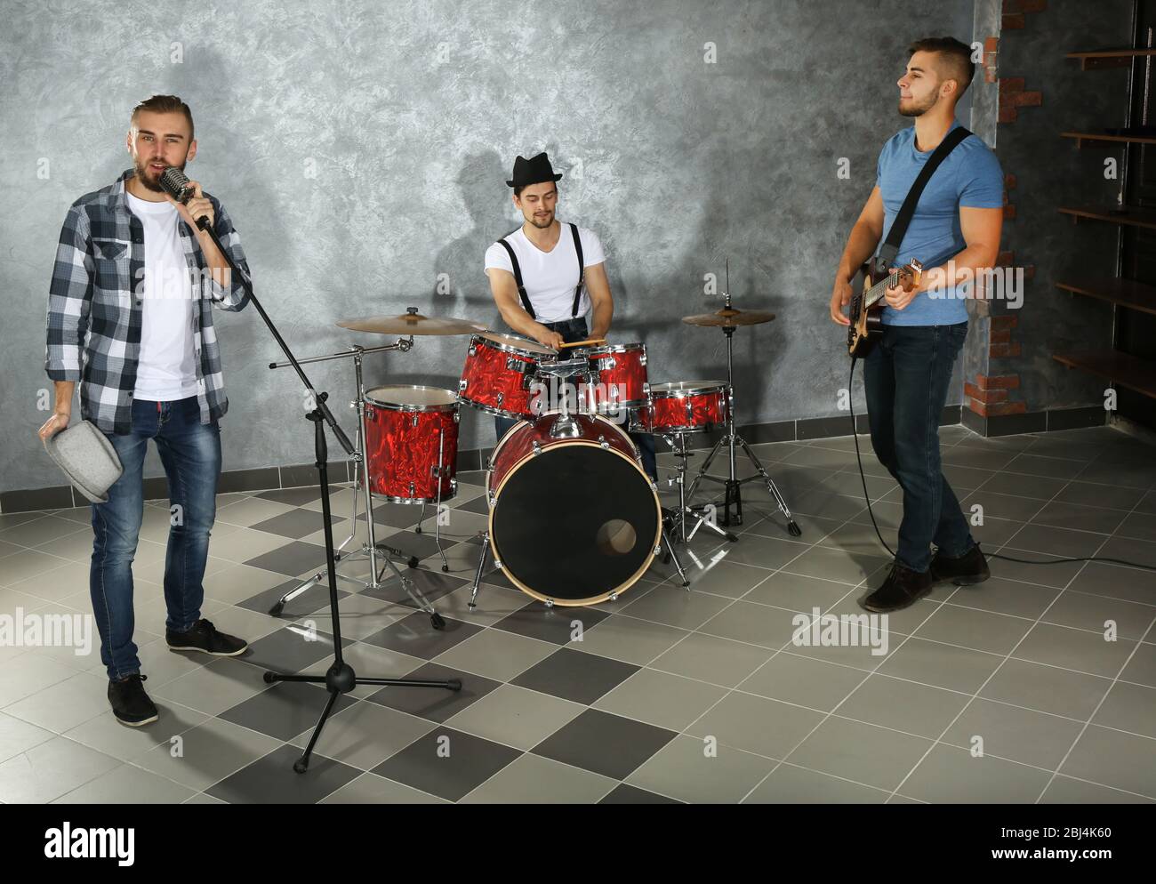 Musicians playing musical instruments and singing songs in a studio ...