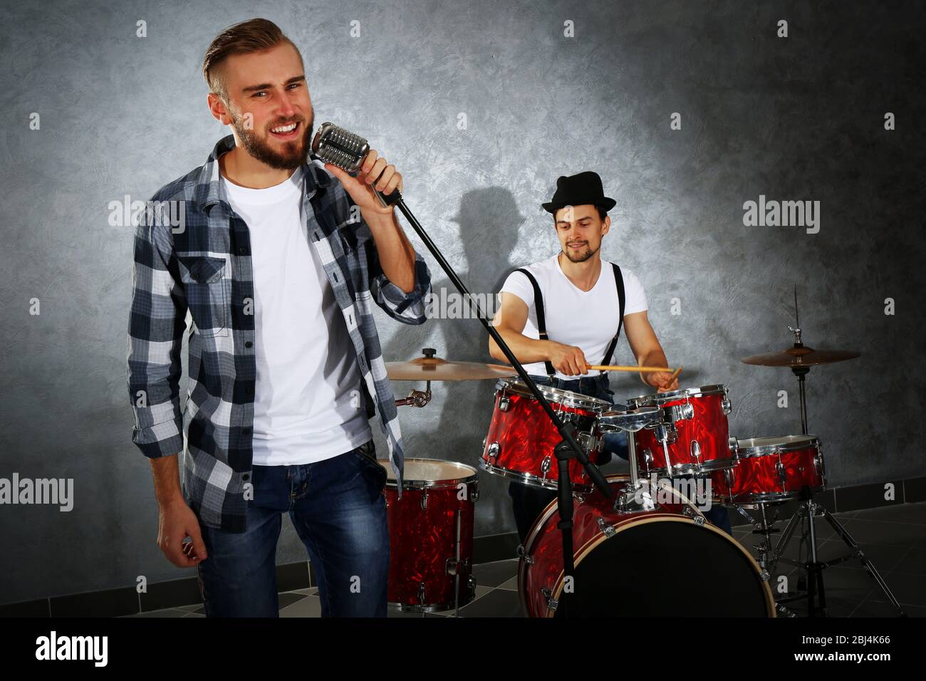 Musicians playing musical instruments and singing songs in a studio ...