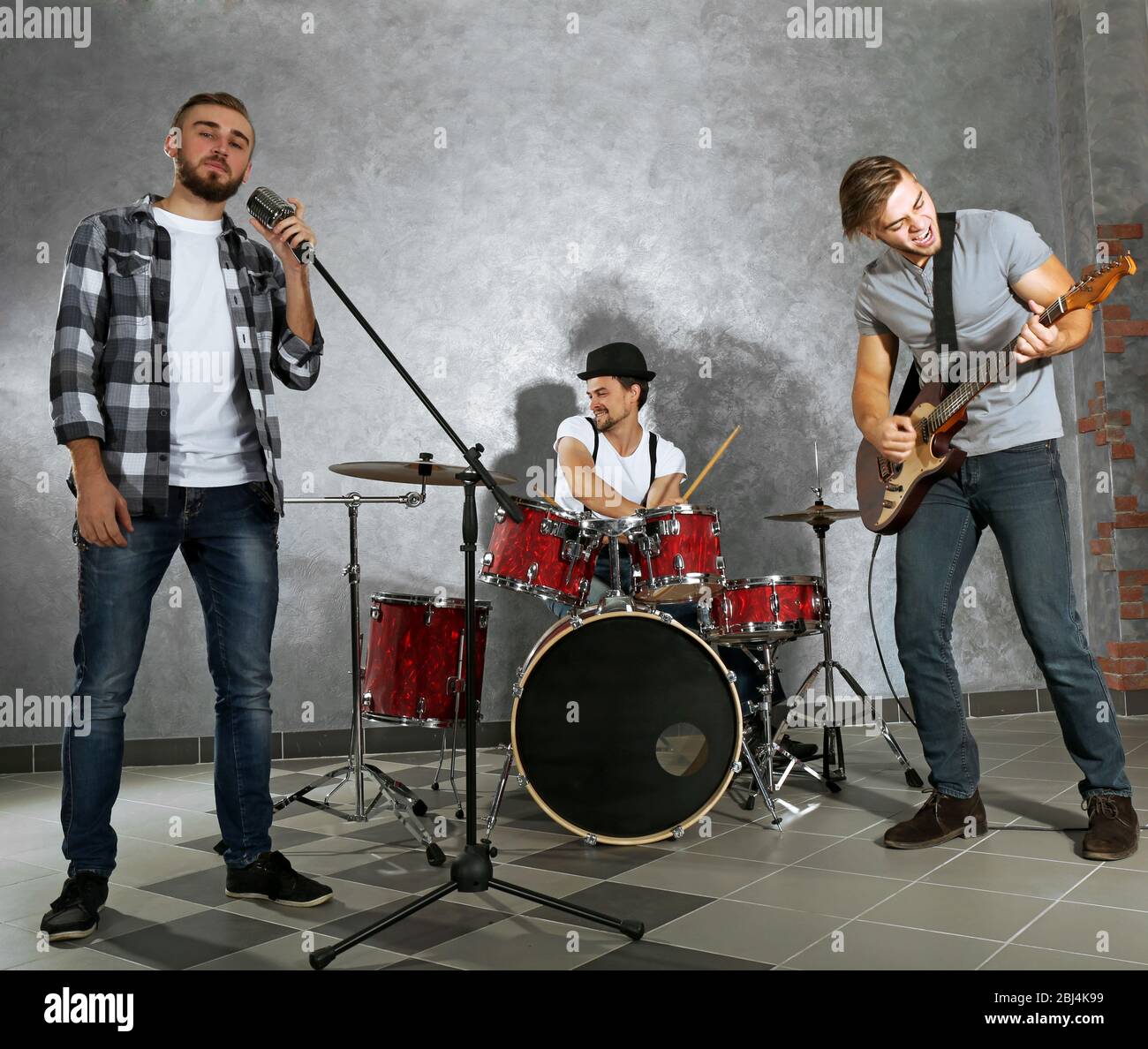 Musicians playing musical instruments and singing songs in a studio ...