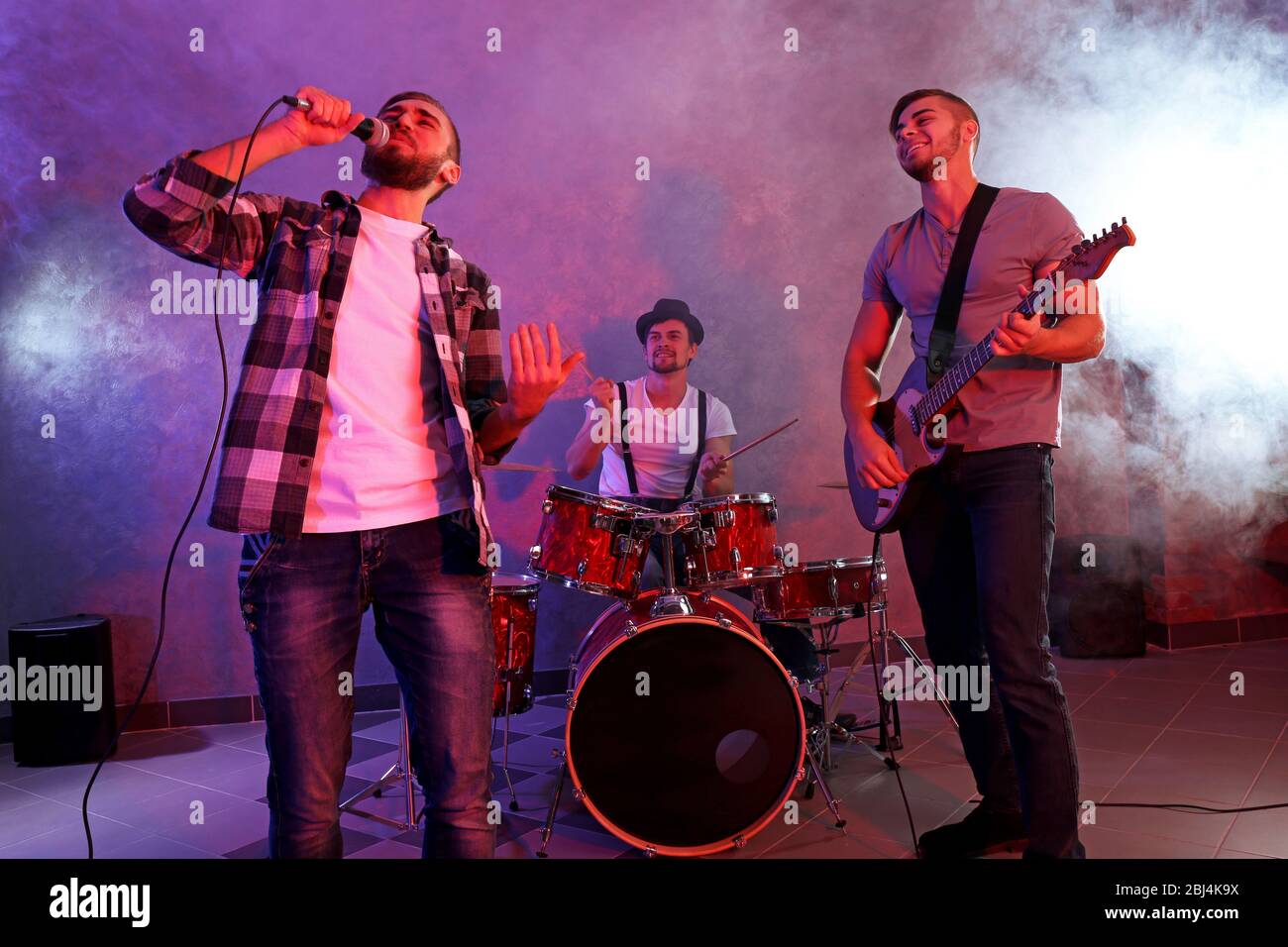 Musicians playing musical instruments and singing songs in a studio ...