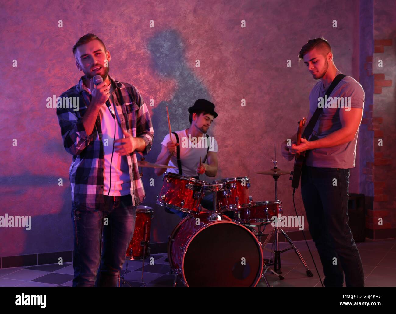 Musicians playing musical instruments and singing songs in a studio ...