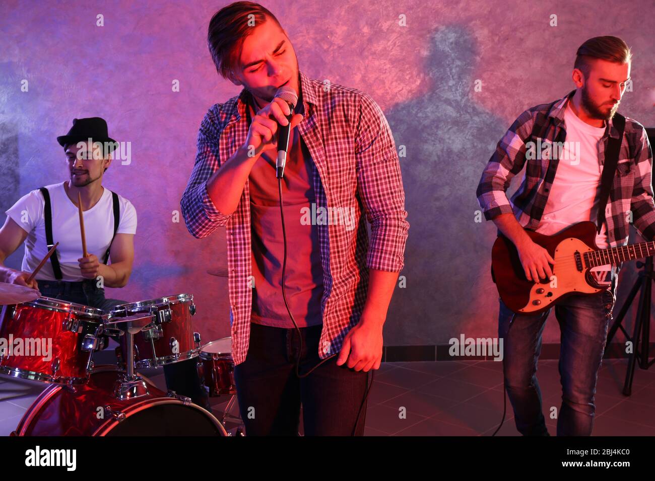 Musicians playing musical instruments and singing songs in a studio ...