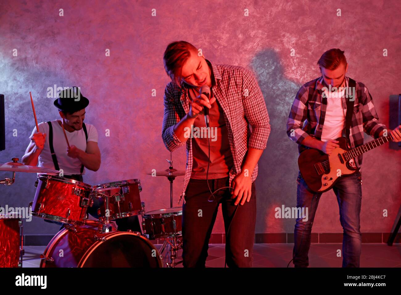 Musicians playing musical instruments and singing songs in a studio ...