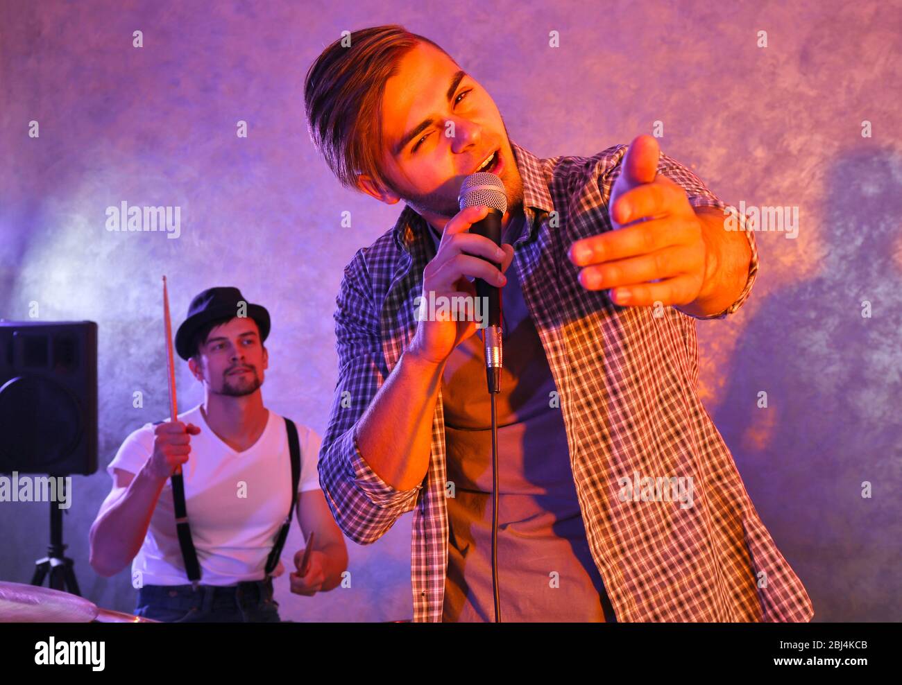 Musicians playing musical instruments and singing songs in a studio ...