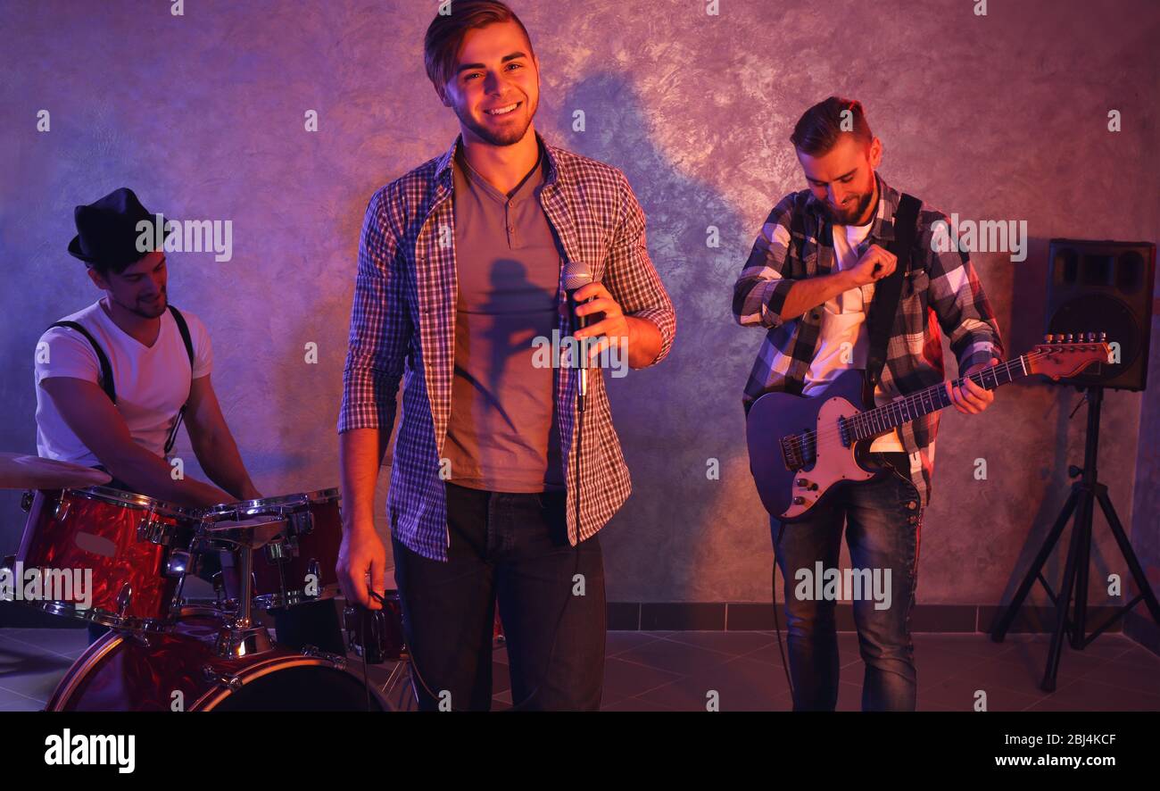 Musicians playing musical instruments and singing songs in a studio ...