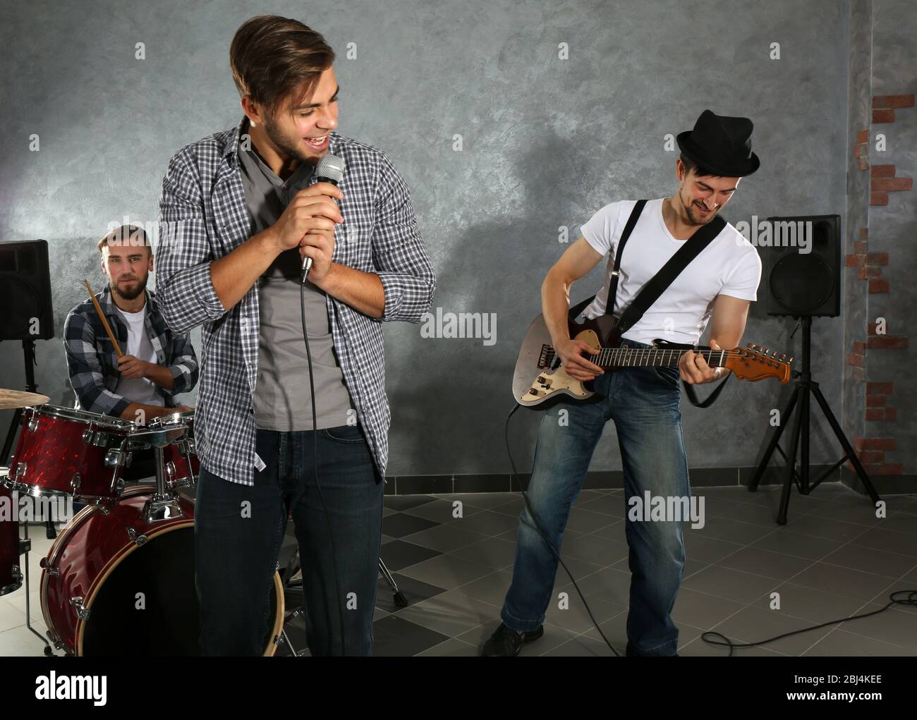 Musicians playing musical instruments and singing songs in a studio ...
