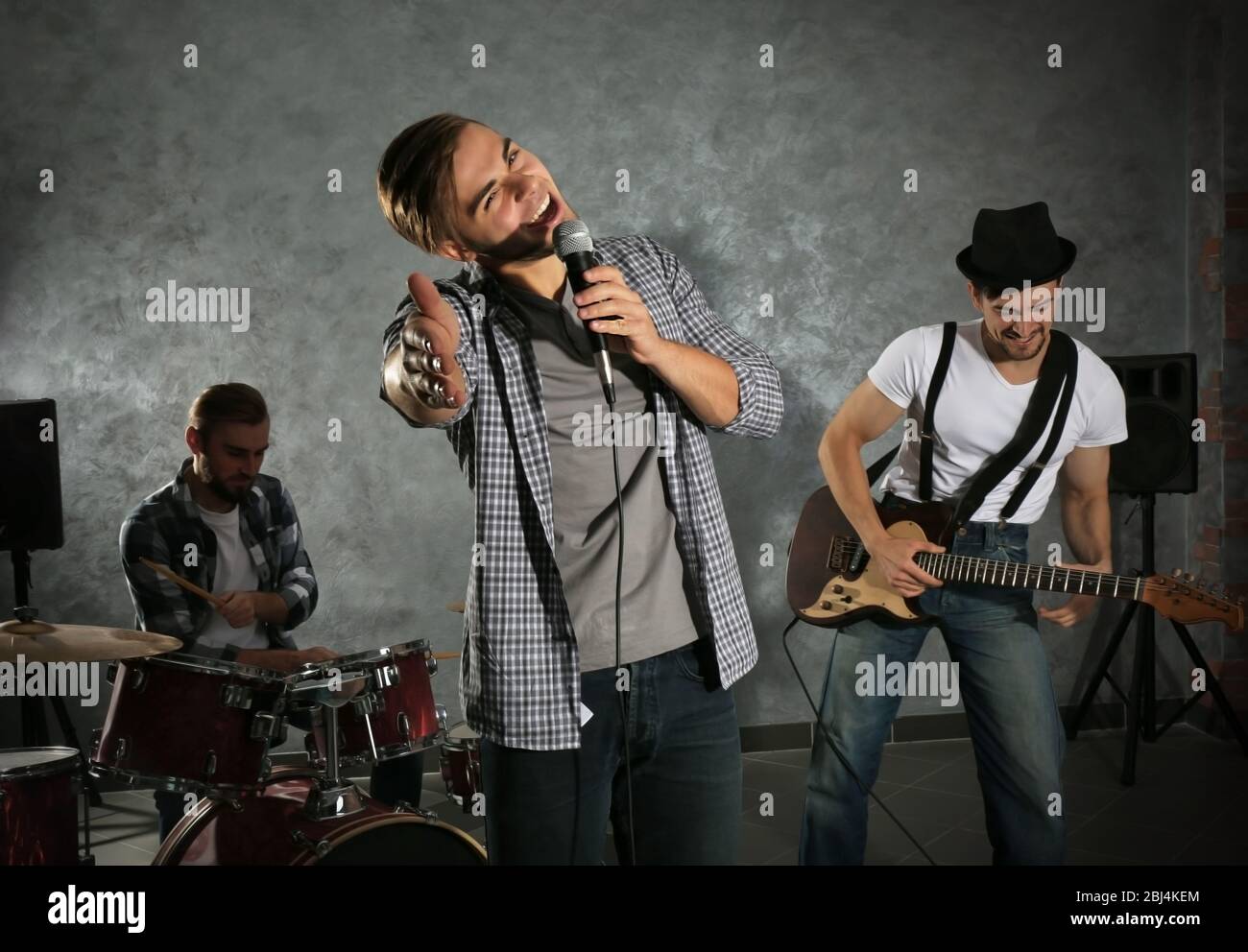 Musicians playing musical instruments and singing songs in a studio ...