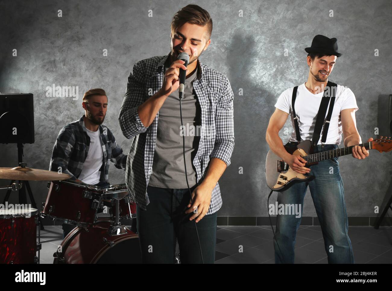 Musicians playing musical instruments and singing songs in a studio ...