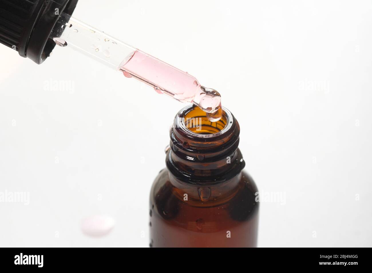 Pipette with drop, close up on white background Stock Photo - Alamy