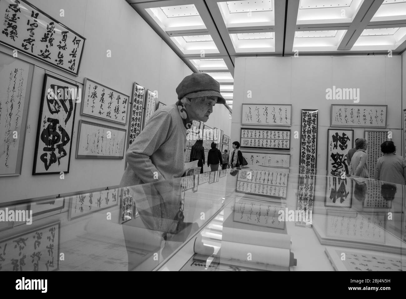 Visitors look at calligraphy artworks at "The National Art Center" in ...