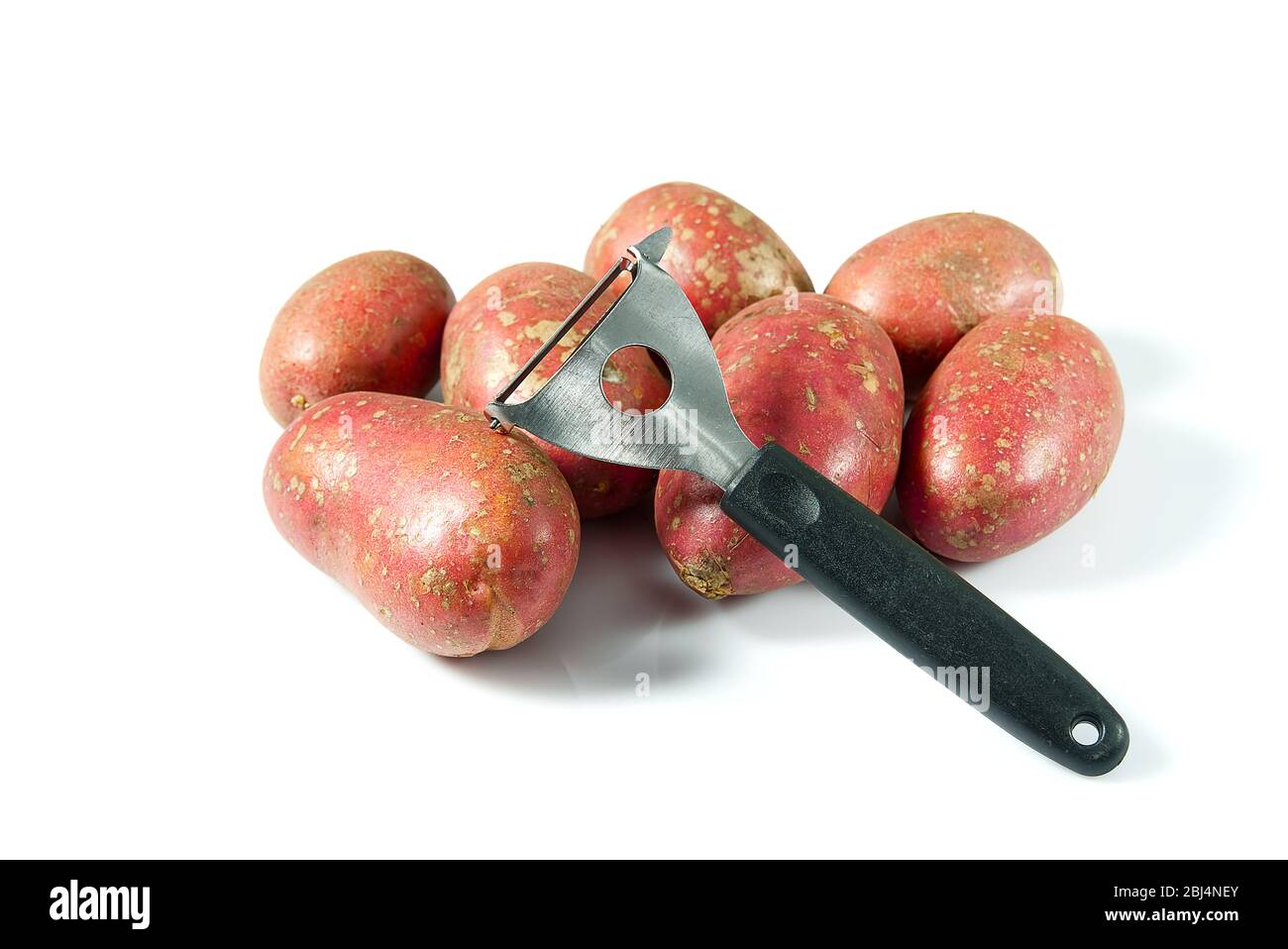 a pile of unpeeled potatoes and black potatoes peeling, white ...