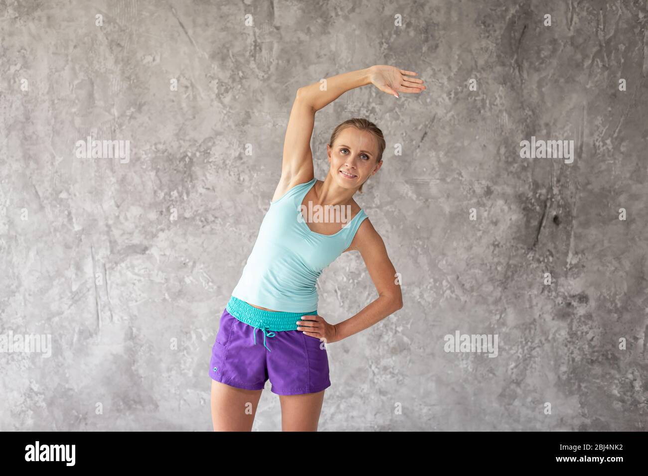 Blond sporty woman trunk bending as part of morning exercises Stock ...