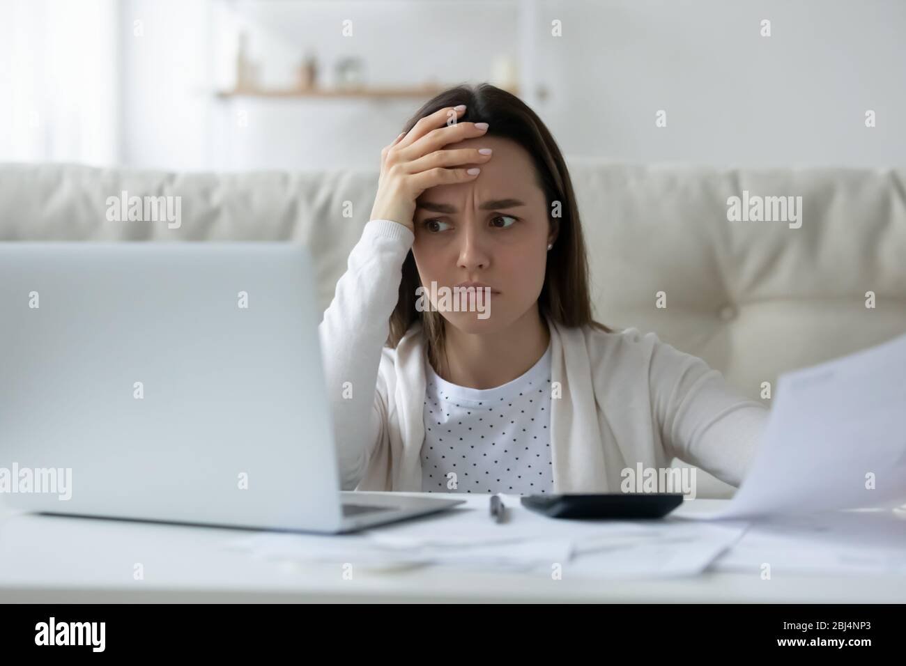 Confused young woman have problems paying bills online Stock Photo - Alamy