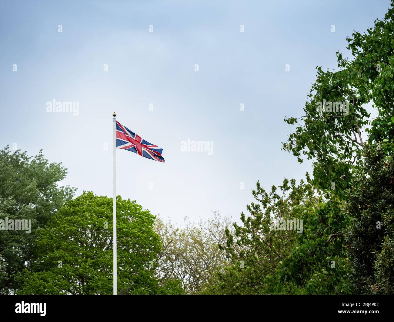 Horizontal shot of Great Britain Union Jack flag flying on a flagpole ...
