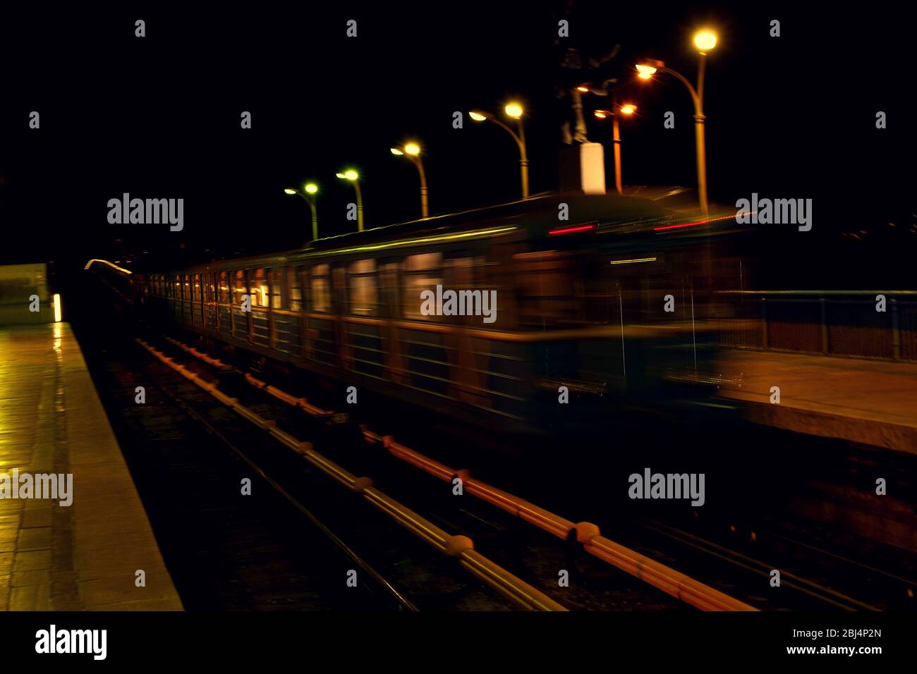 Moving train on the bridge at night Stock Photo - Alamy