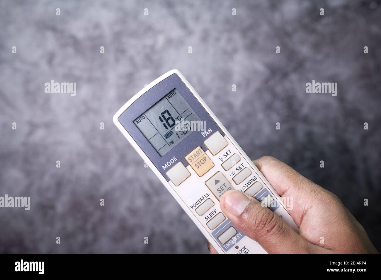 Air conditioner temperature adjustment with remote controller Stock ...