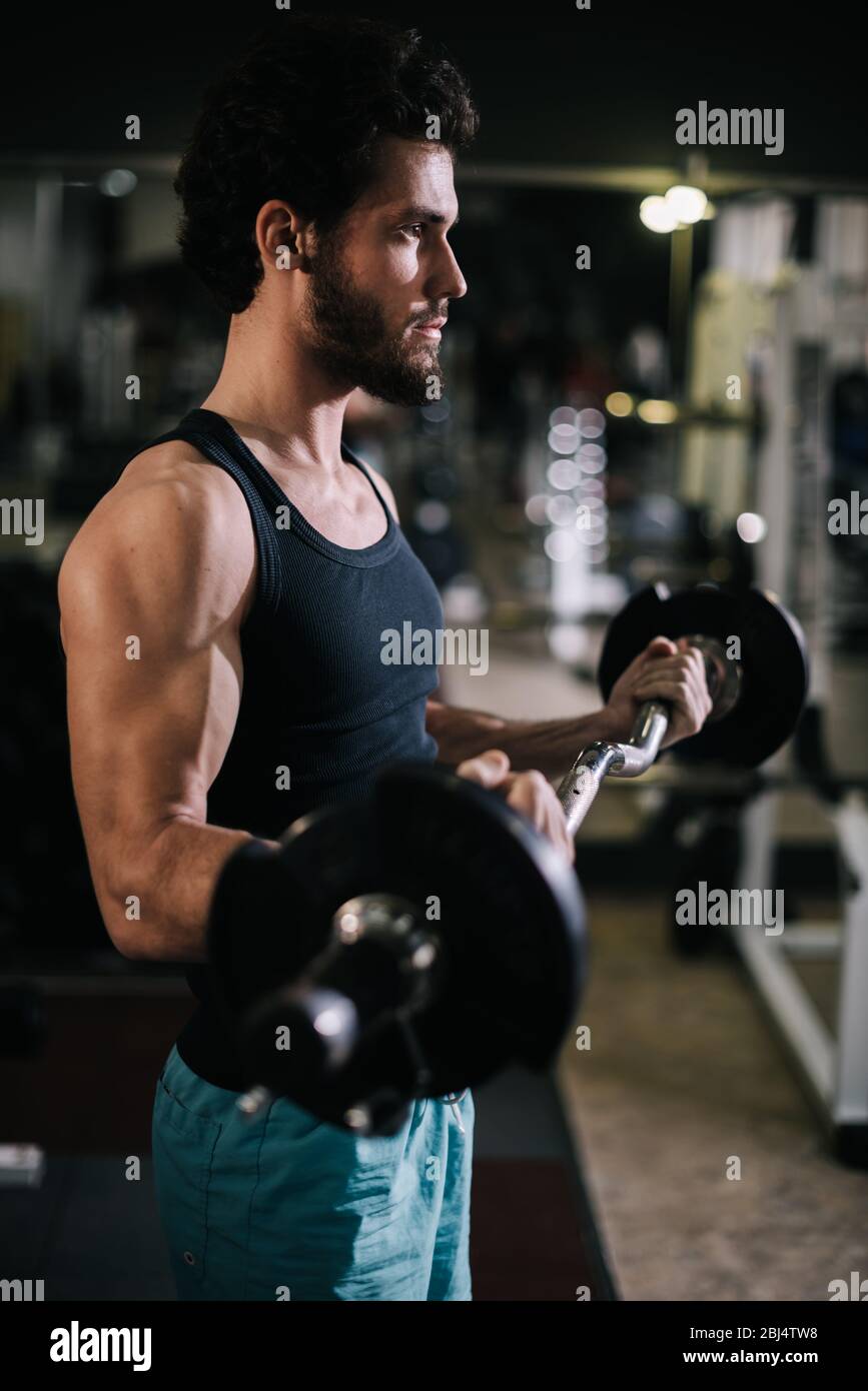 Side view of sportive bearded young man with muscular body working out ...