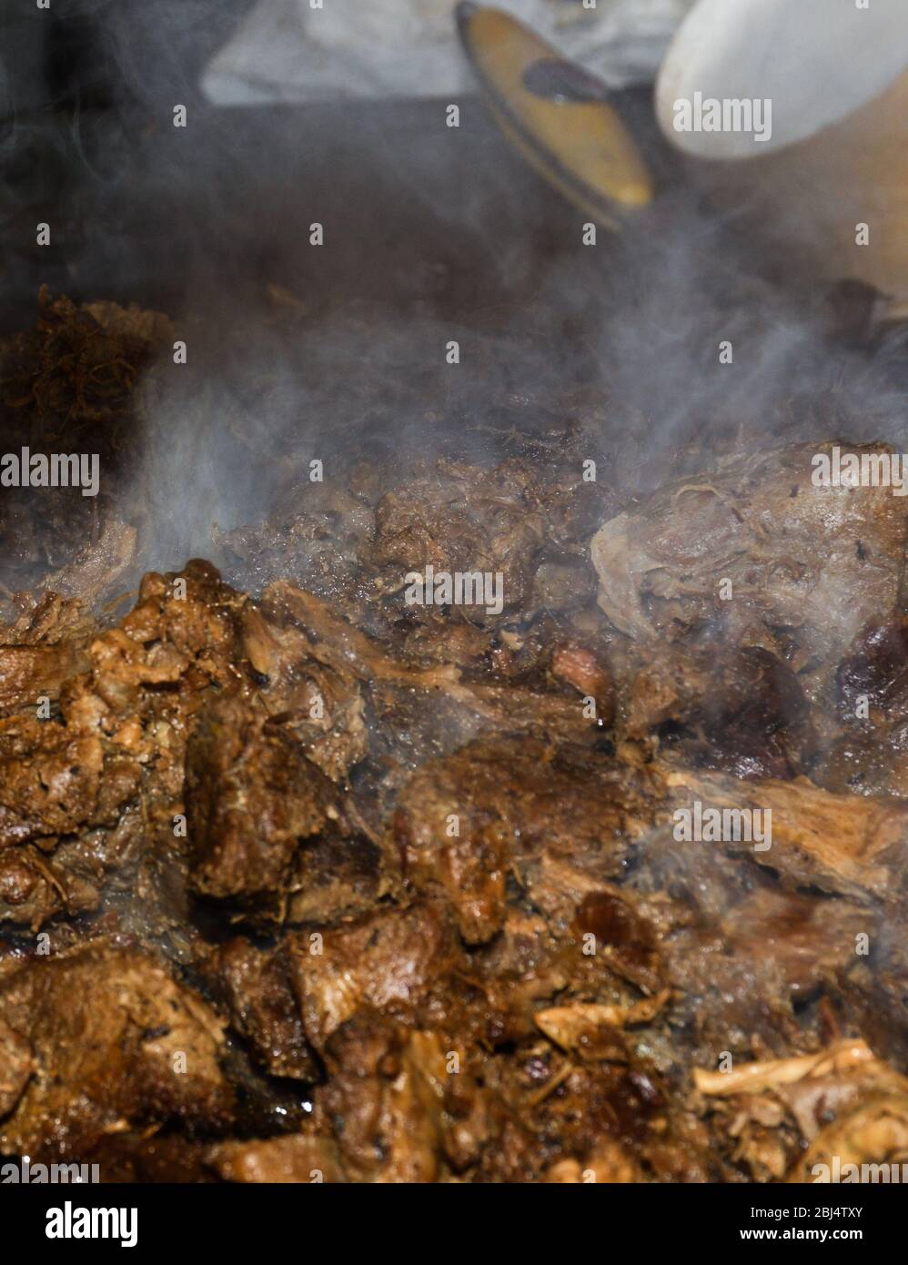 Unhealthy, greasy, oily, mix of meat slices, frying in a large pot ...