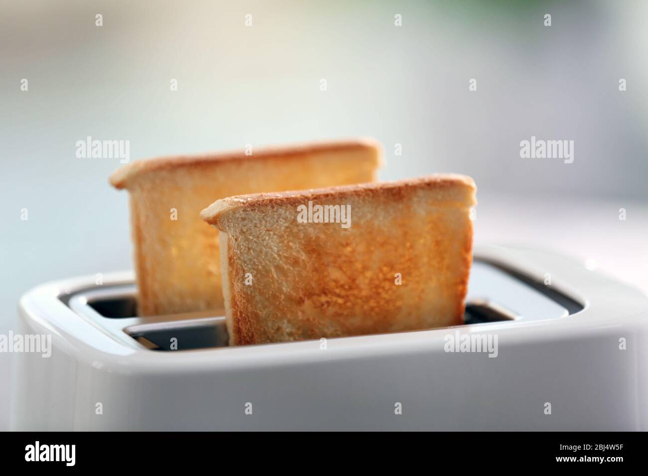 A couple of crusty toast in the toaster, close-up Stock Photo - Alamy