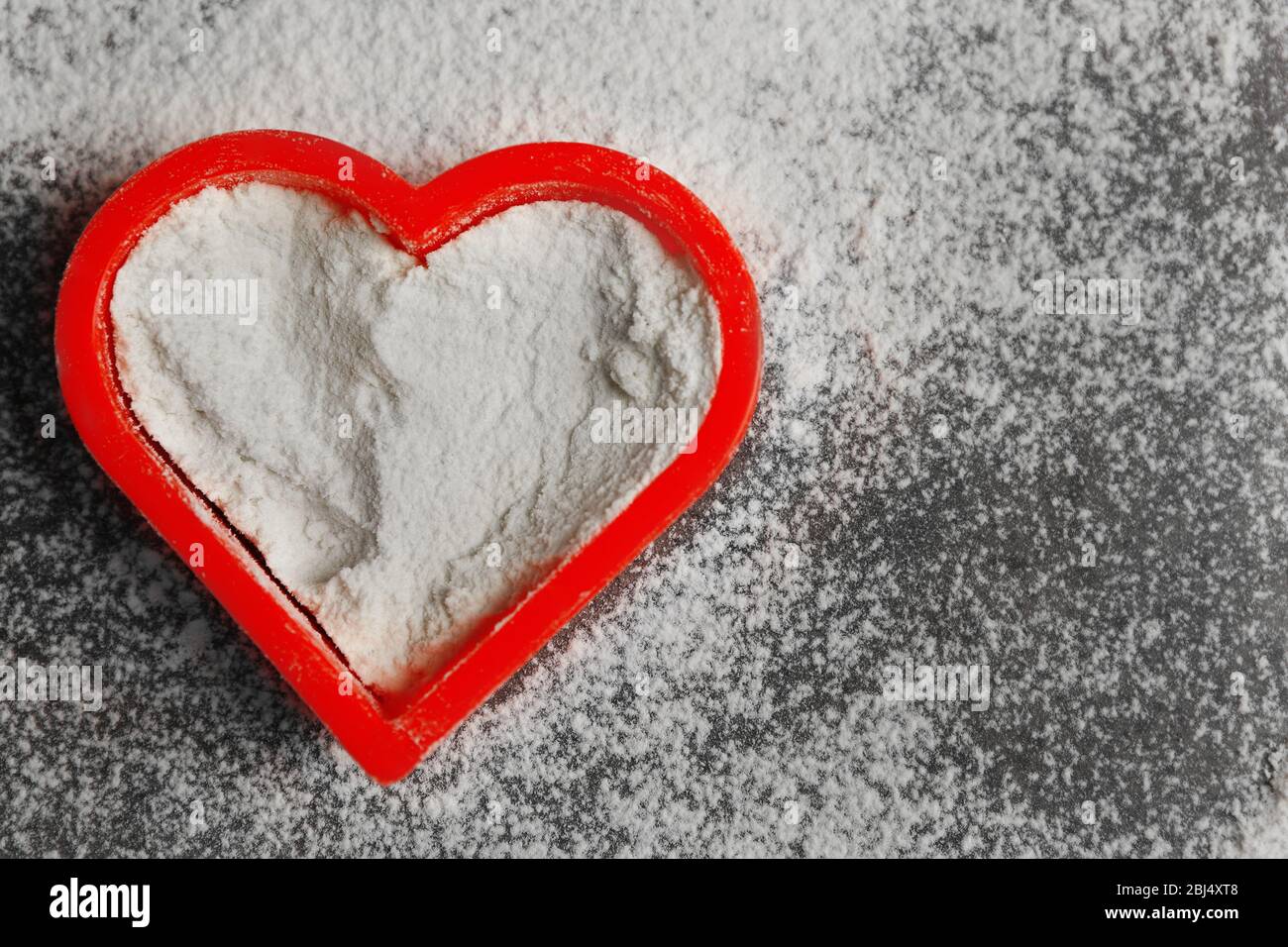 Heart of flour on gray background Stock Photo - Alamy