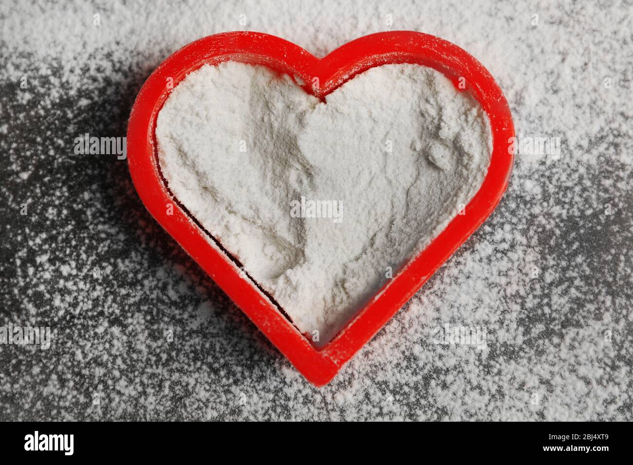 Heart of flour on gray background Stock Photo - Alamy