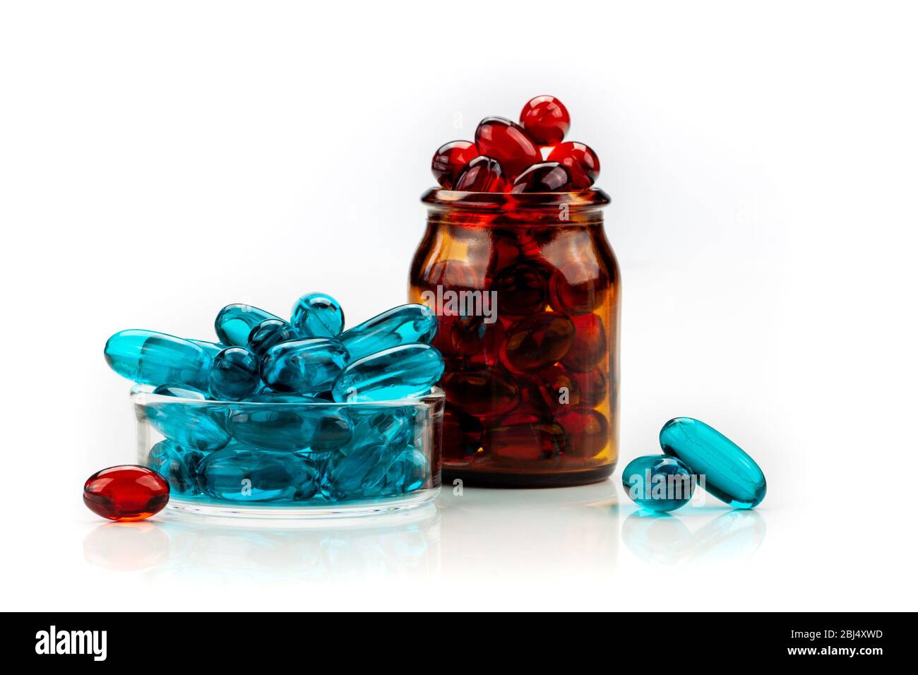 A mix of multicolored medical soft gel capsules on a white background ...