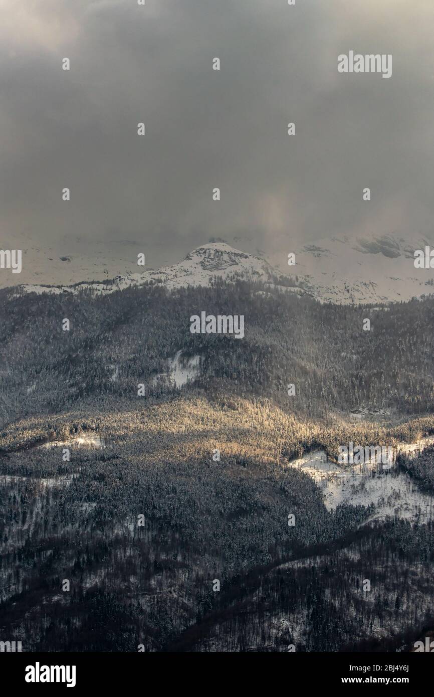 Patches of light on valley forest with mountains landscape hi-res stock ...