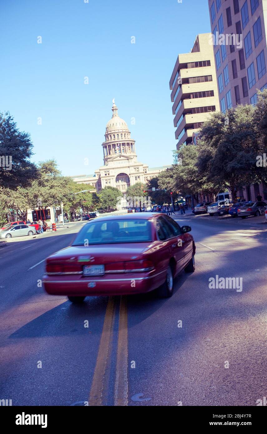 Car in the middle of a street in Austin in Texas with the Texas Capitol ...