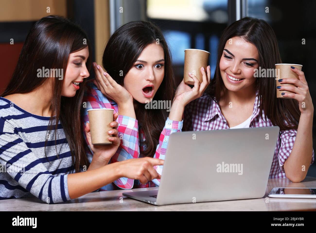 Best friends with laptop together sitting in cafe Stock Photo - Alamy