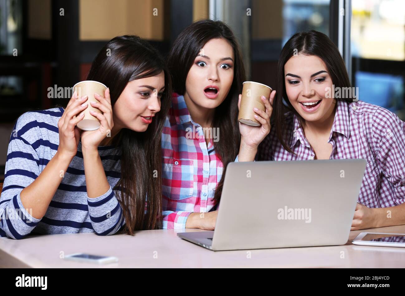 Best friends with laptop together sitting in cafe Stock Photo - Alamy