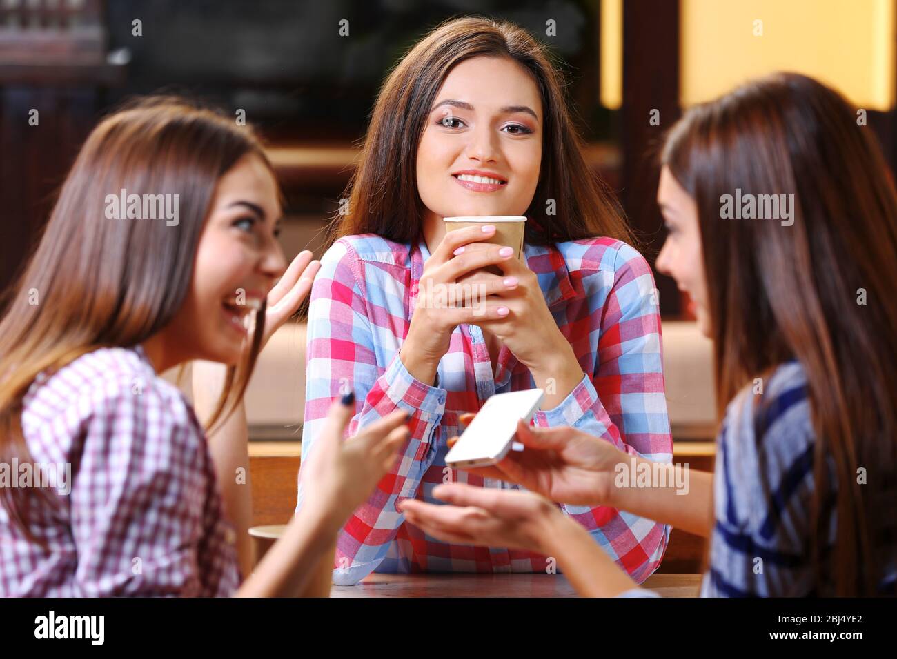Beautiful girls speaking in cafe Stock Photo - Alamy