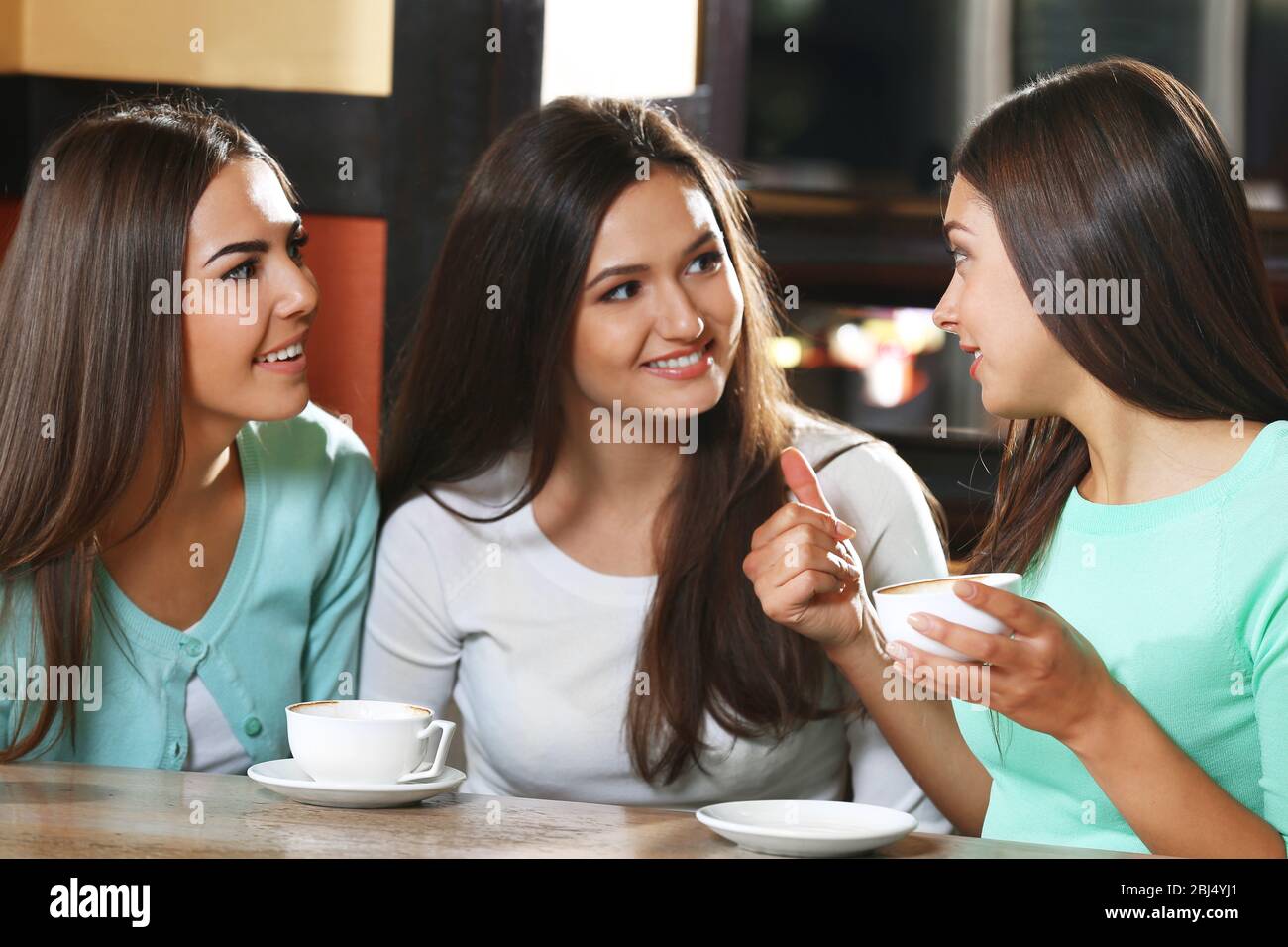 Beautiful girls gossip in cafe Stock Photo - Alamy