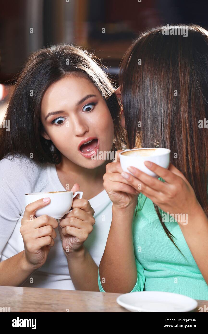 Beautiful girls gossip in cafe Stock Photo - Alamy