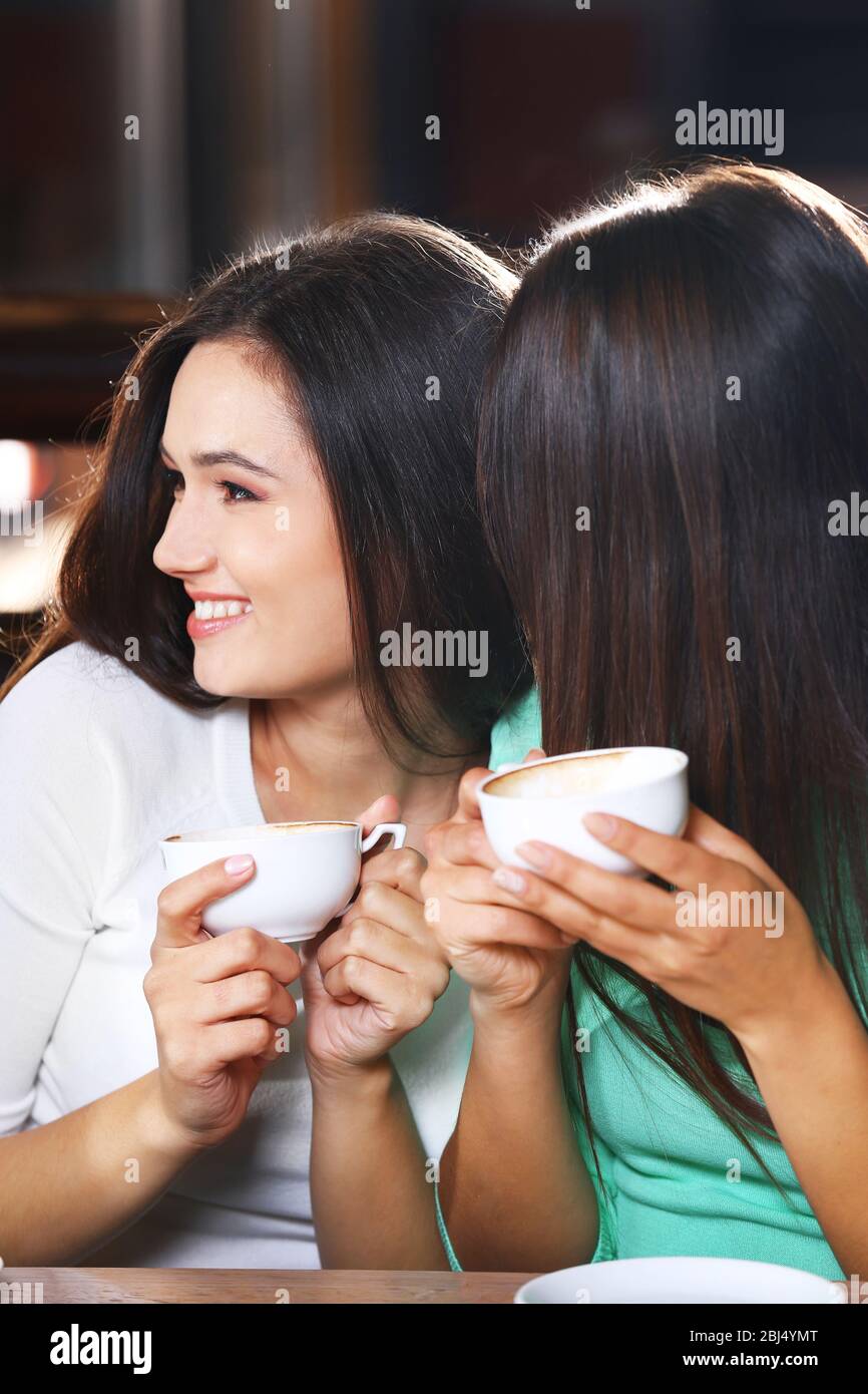 Beautiful girls gossip in cafe Stock Photo - Alamy