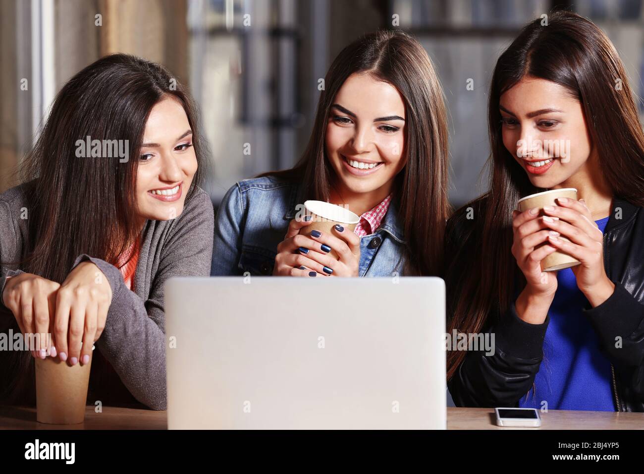 Best friends with laptop together sitting at cafes terrace Stock Photo ...